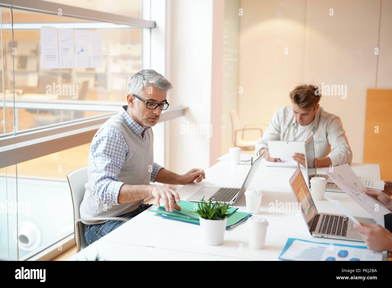 Teacher meeting around table with students Stock Photo - Alamy