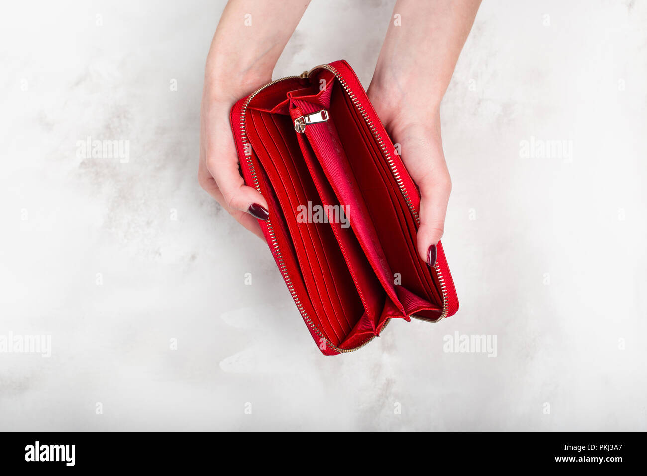 Stylish empty female red purse in female hands on a white texture Stock ...