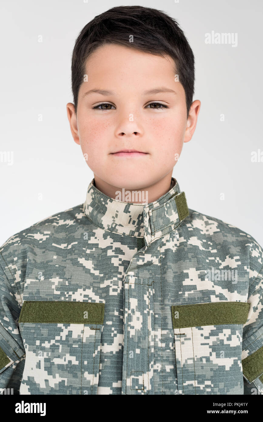 portrait of little kid in military uniform looking at camera on grey ...
