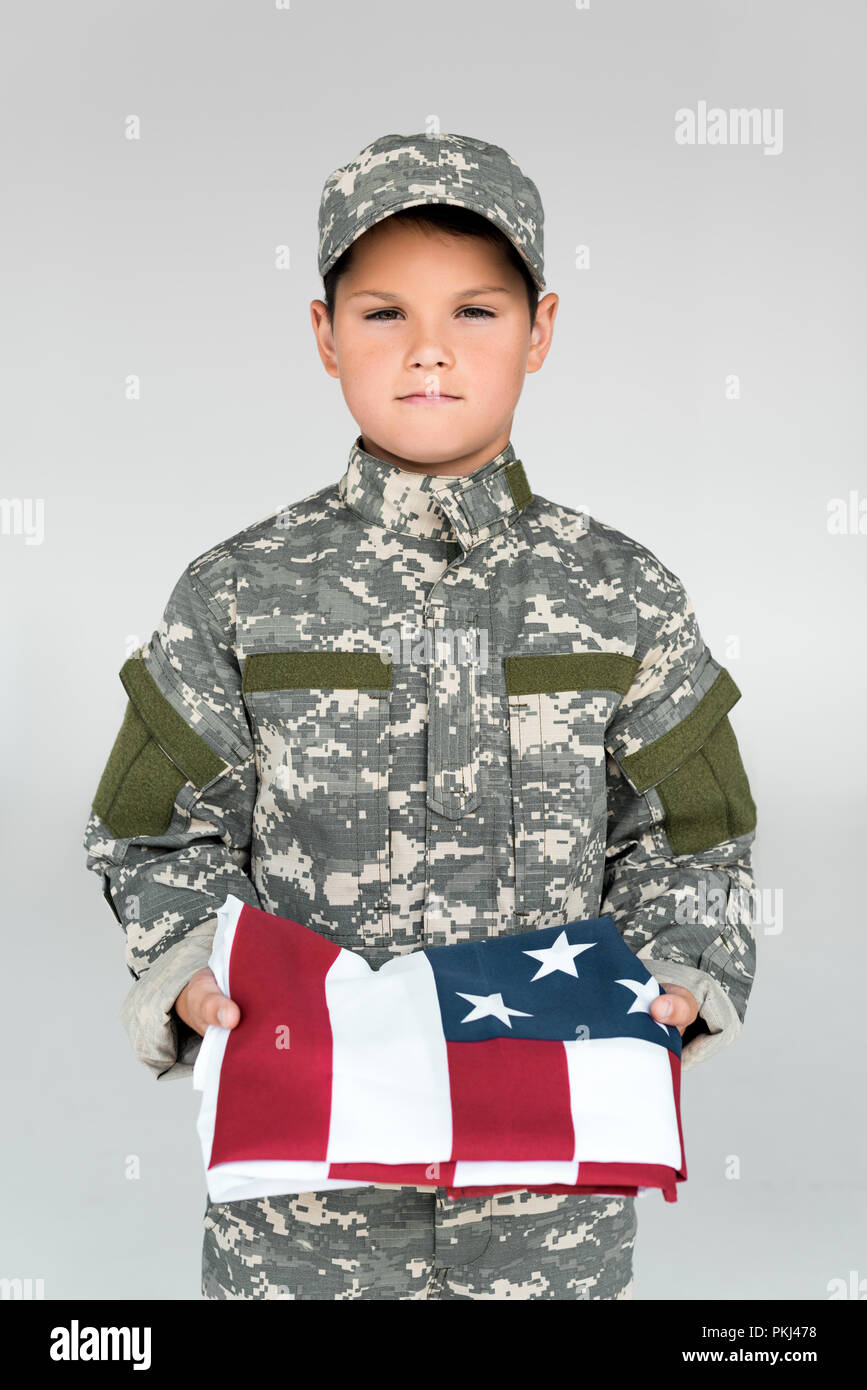 portrait of kid in military uniform holding folded american flag ...