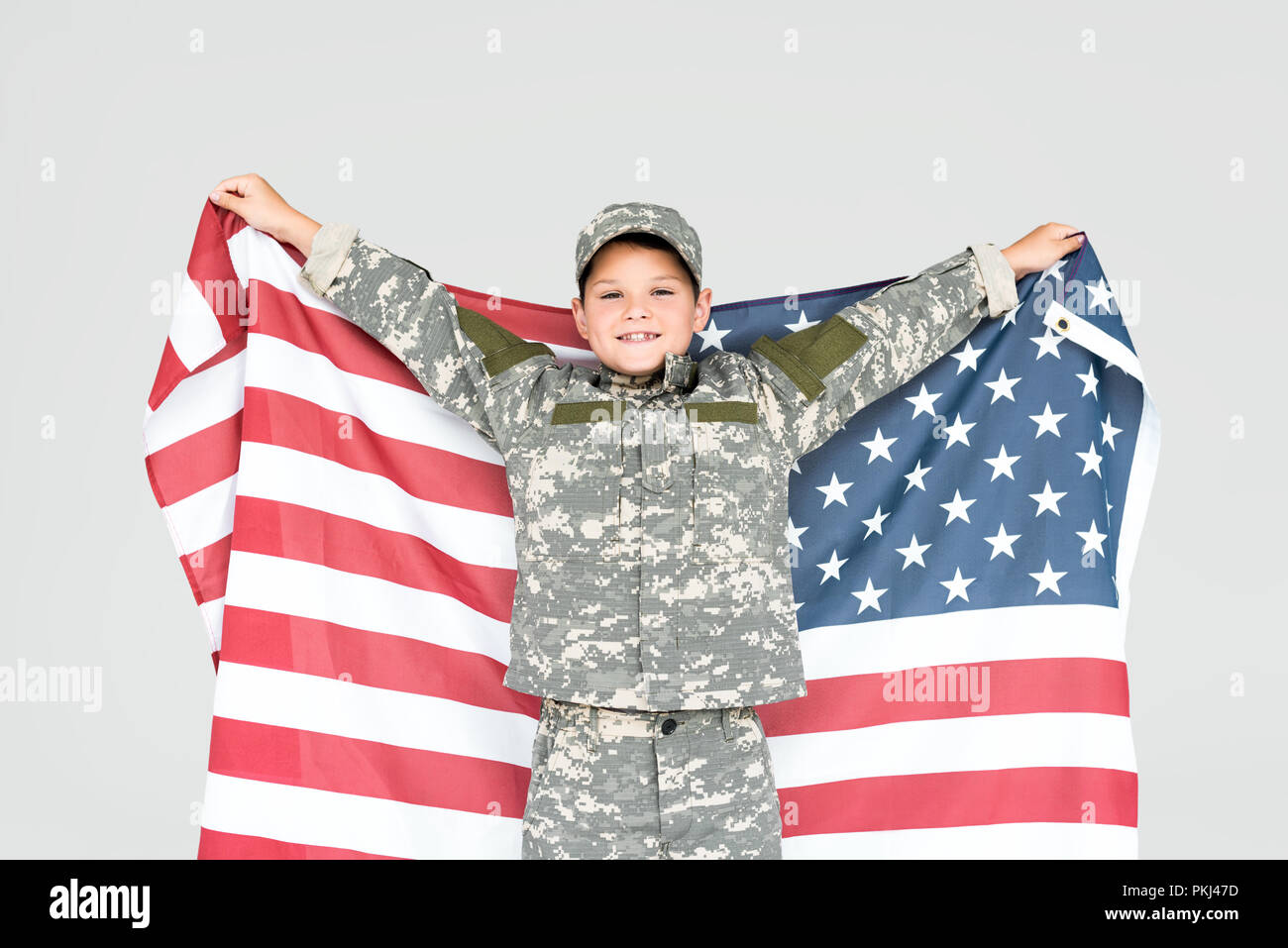 portrait of cheerful kid in military uniform with american flag ...