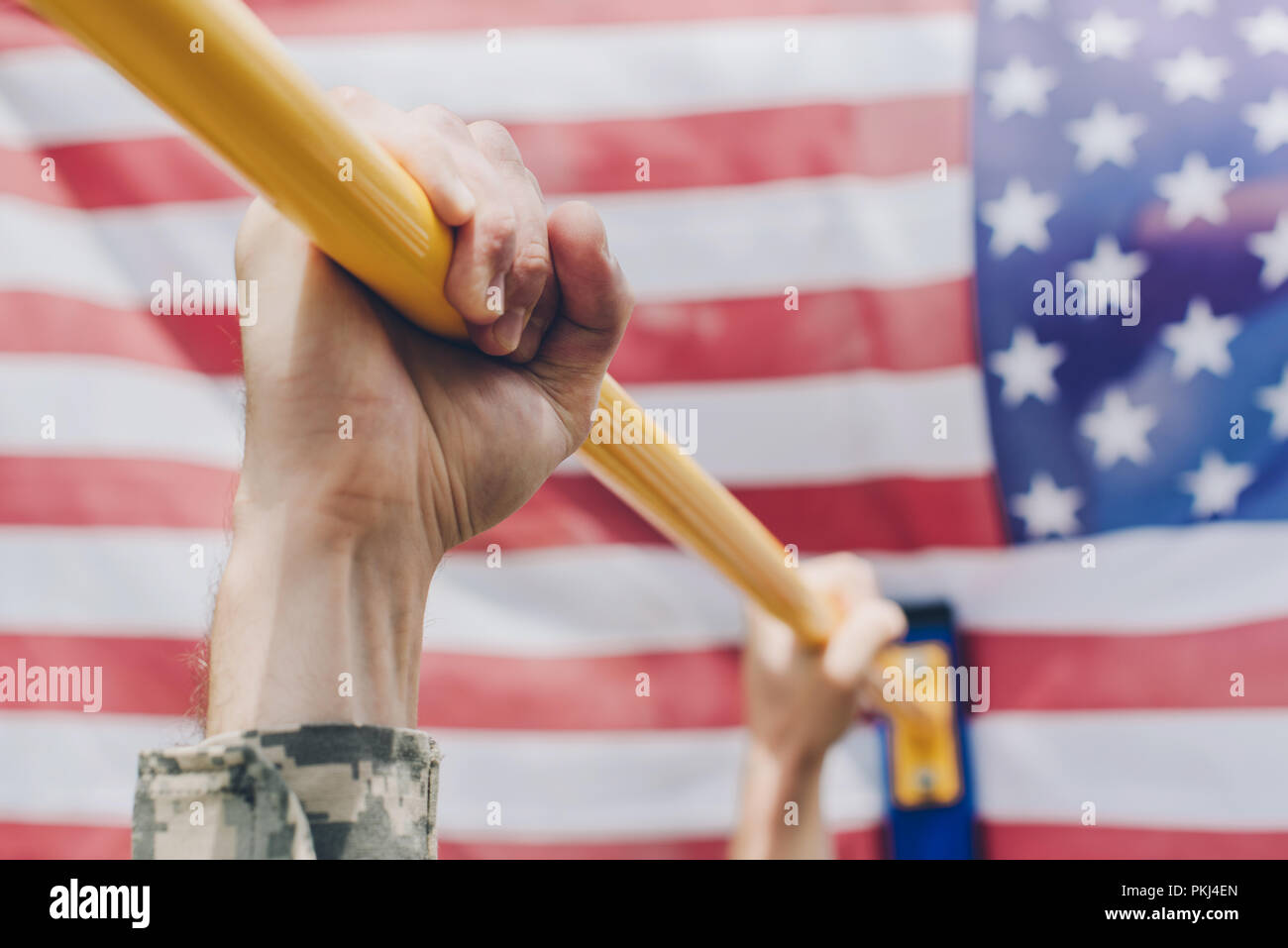partial view of soldier pulling himself up on crossbar with american ...