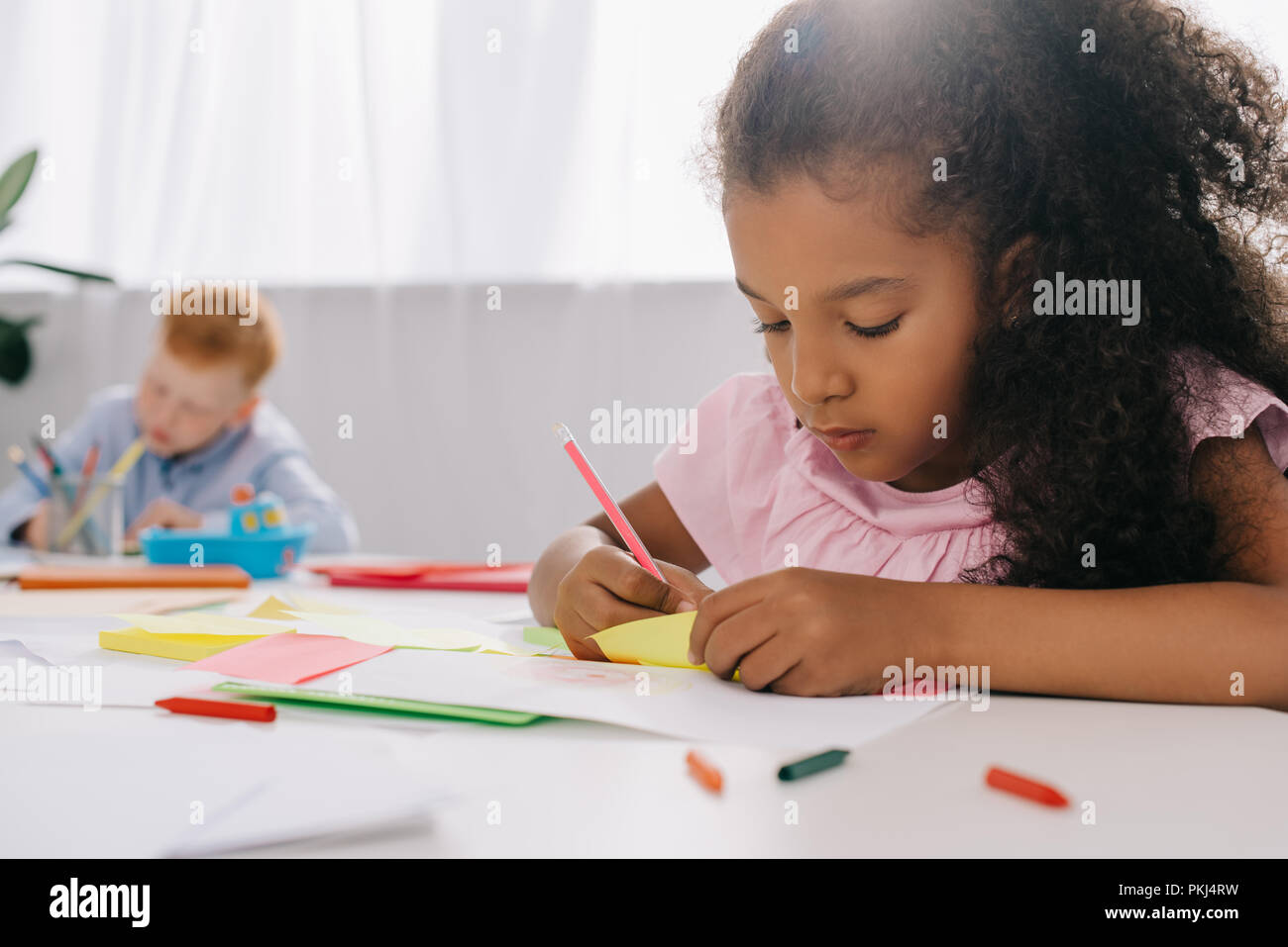 selective focus of multicultural preschoolers drawing pictures with ...