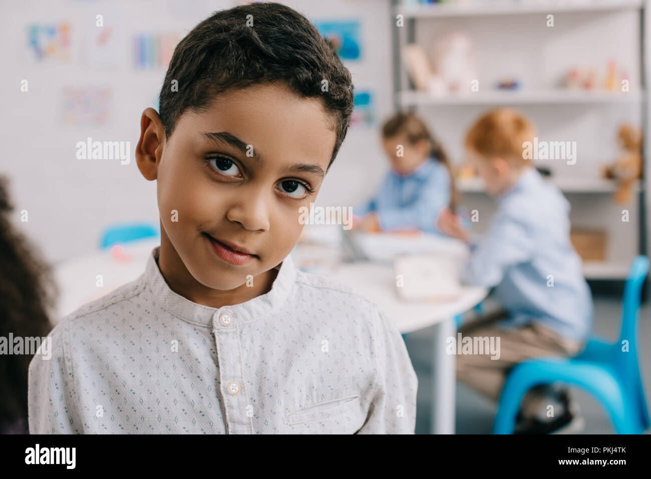 selective focus of cute african american boy looking at camera with ...
