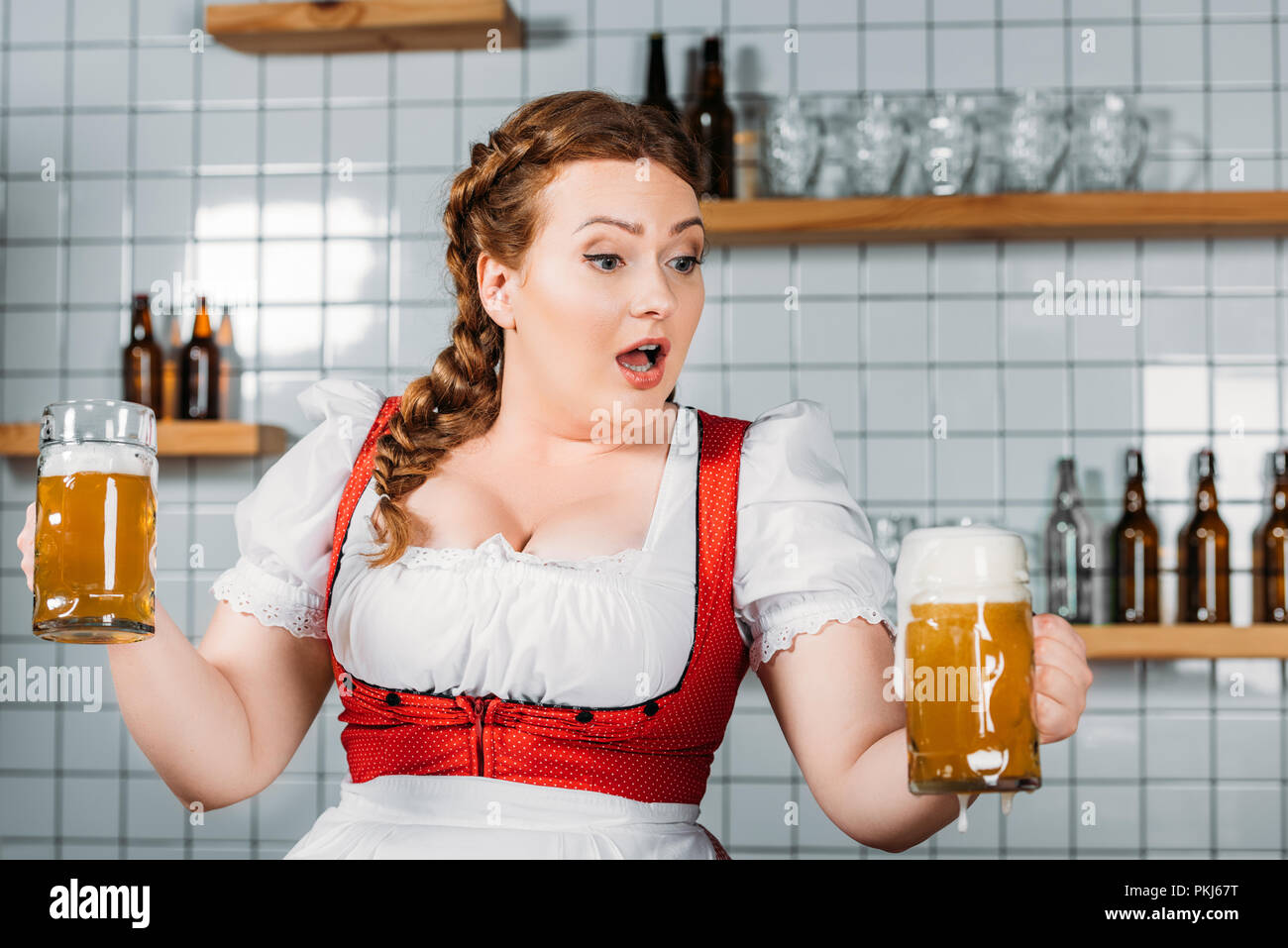 shocked oktoberfest waitress in traditional bavarian dress holding mugs ...