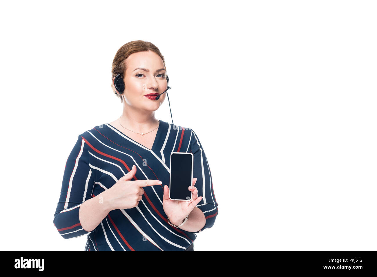 female operator of call center with headset pointing at smartphone with ...