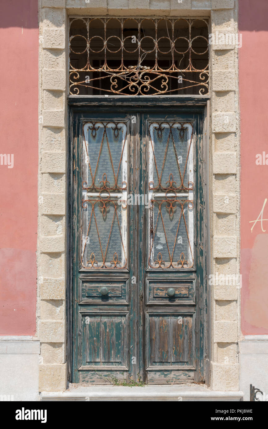 old green door with peeling and flaking paintwork on a building in the ...