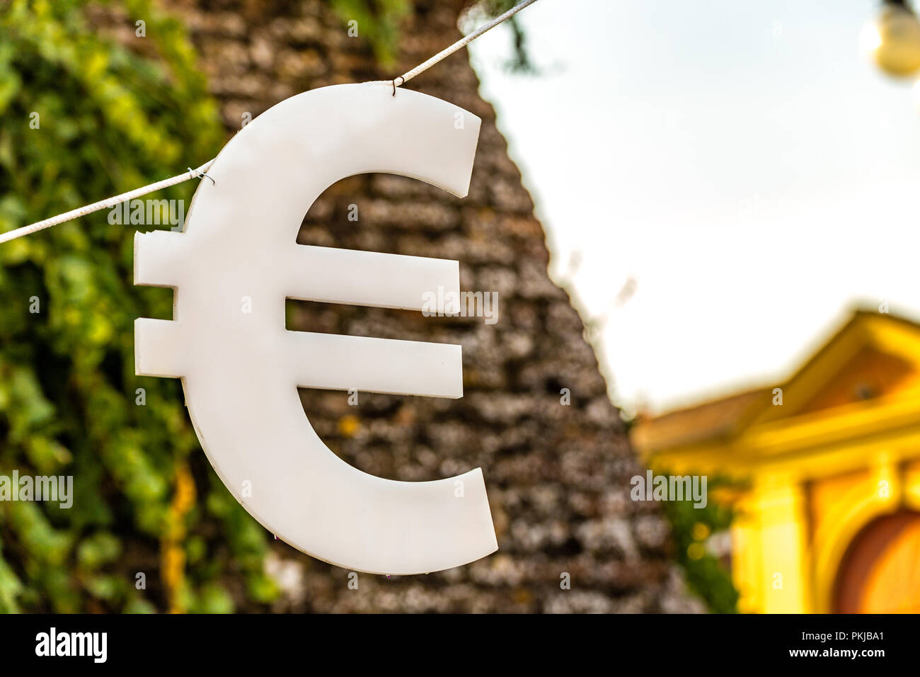 white euro sign hanging on bricks background Stock Photo - Alamy