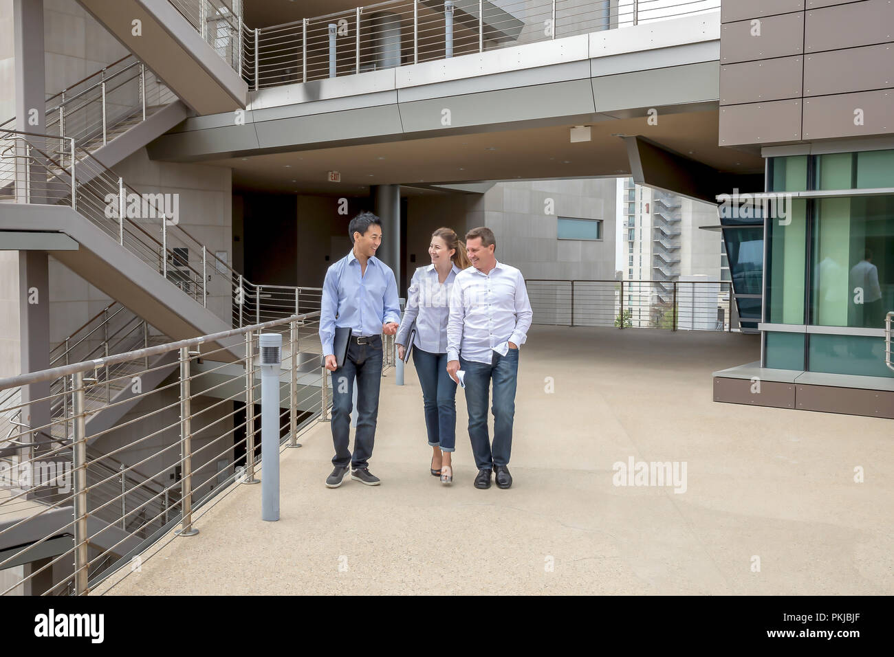 Three colleagues talking together Stock Photo - Alamy