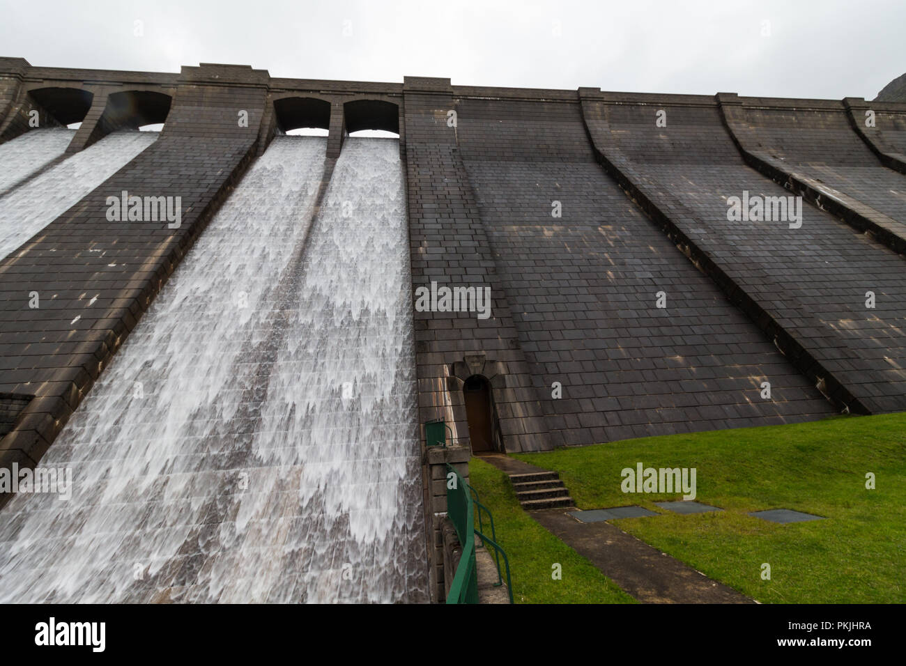 Water is cascading down the dam wall at Ben Crom Reservoir in the heart ...