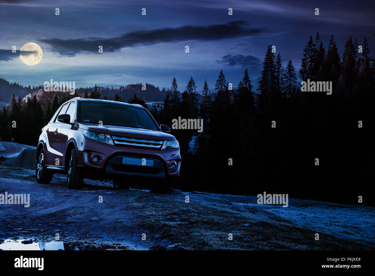 orange 4wd suv parked in mountain at night in full moon light ...