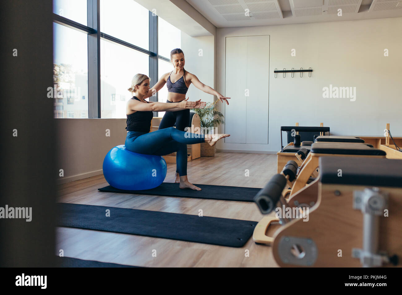 Female pilates instructor training a woman in pilates workout. Woman ...