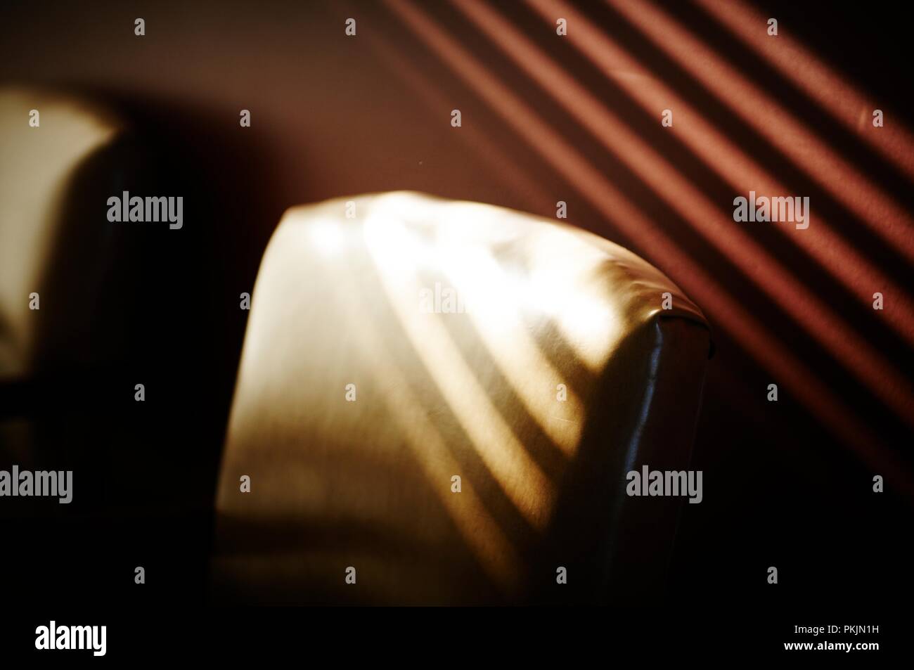 An antique chair with venetian blind shadows across it Stock Photo - Alamy