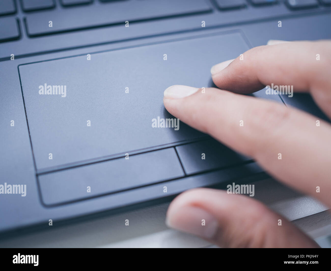 Close-up hands touching on touch pad on black laptop computer keyboard ...