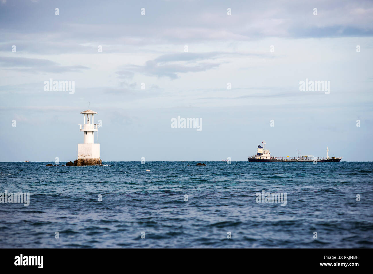 Lighthouse and ship in the sea Stock Photo - Alamy