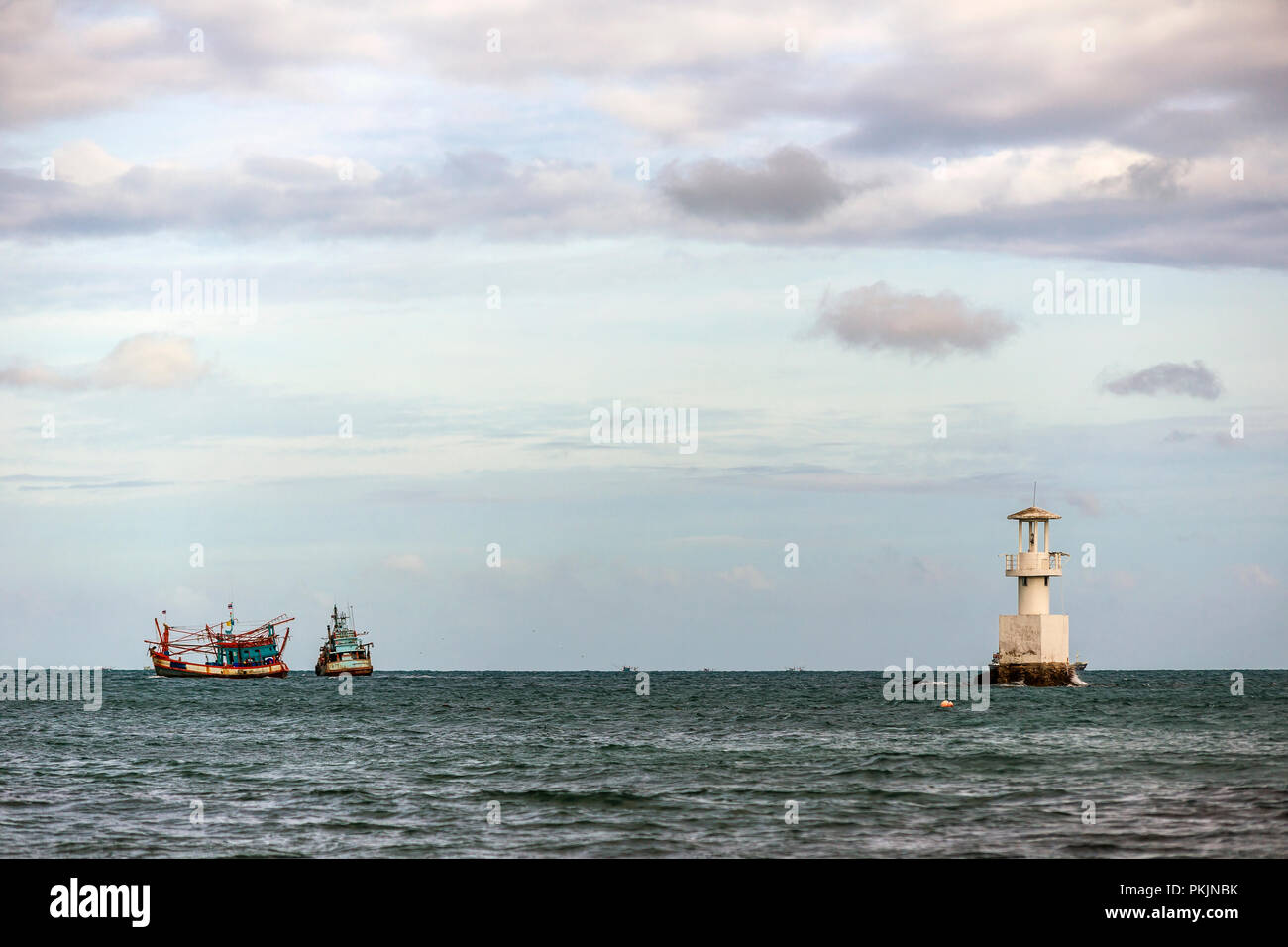 Lighthouse and fishing boat in the sea Stock Photo - Alamy