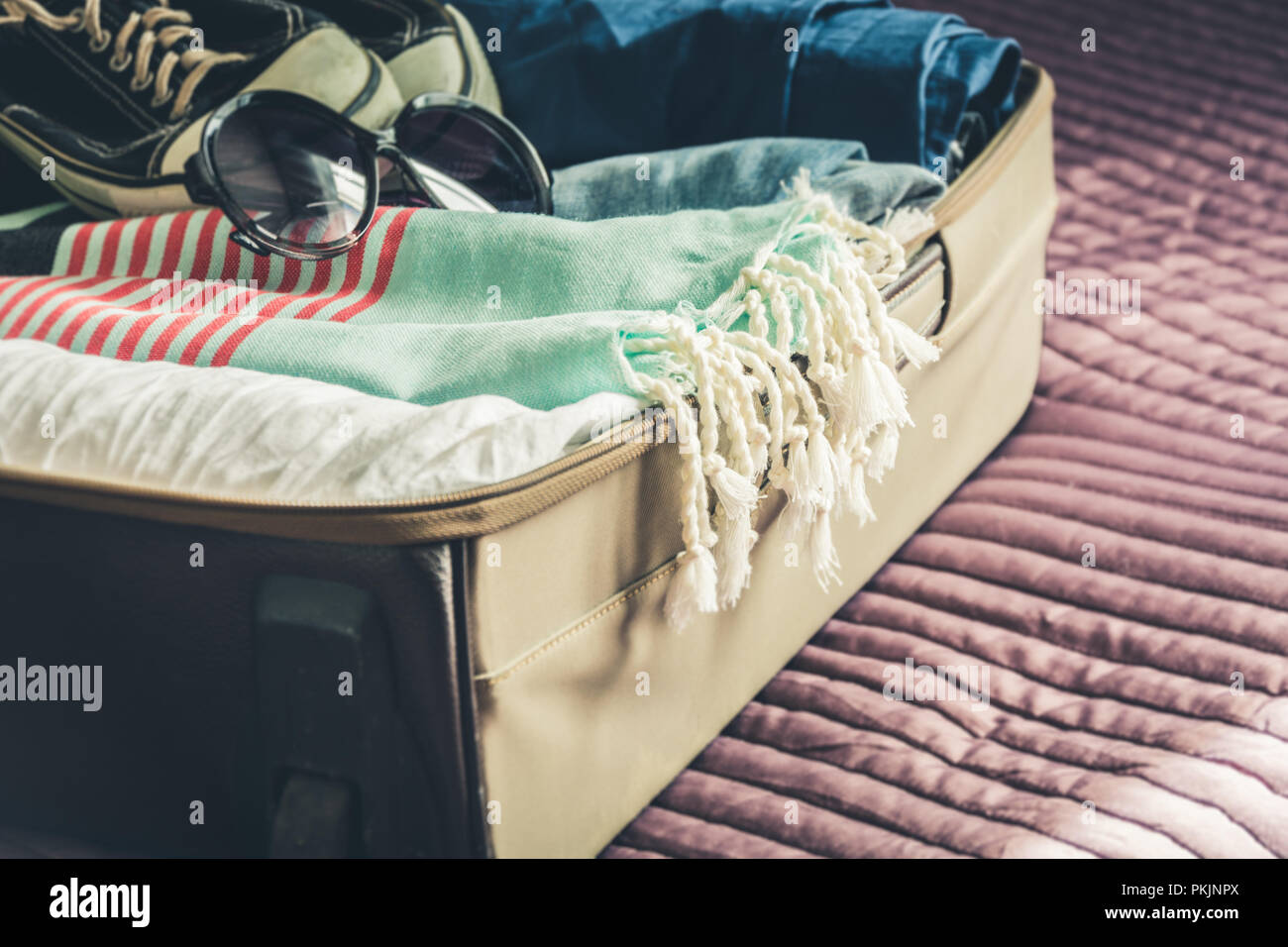 Open suitcase with female clothes for trip. Packing things Stock Photo ...