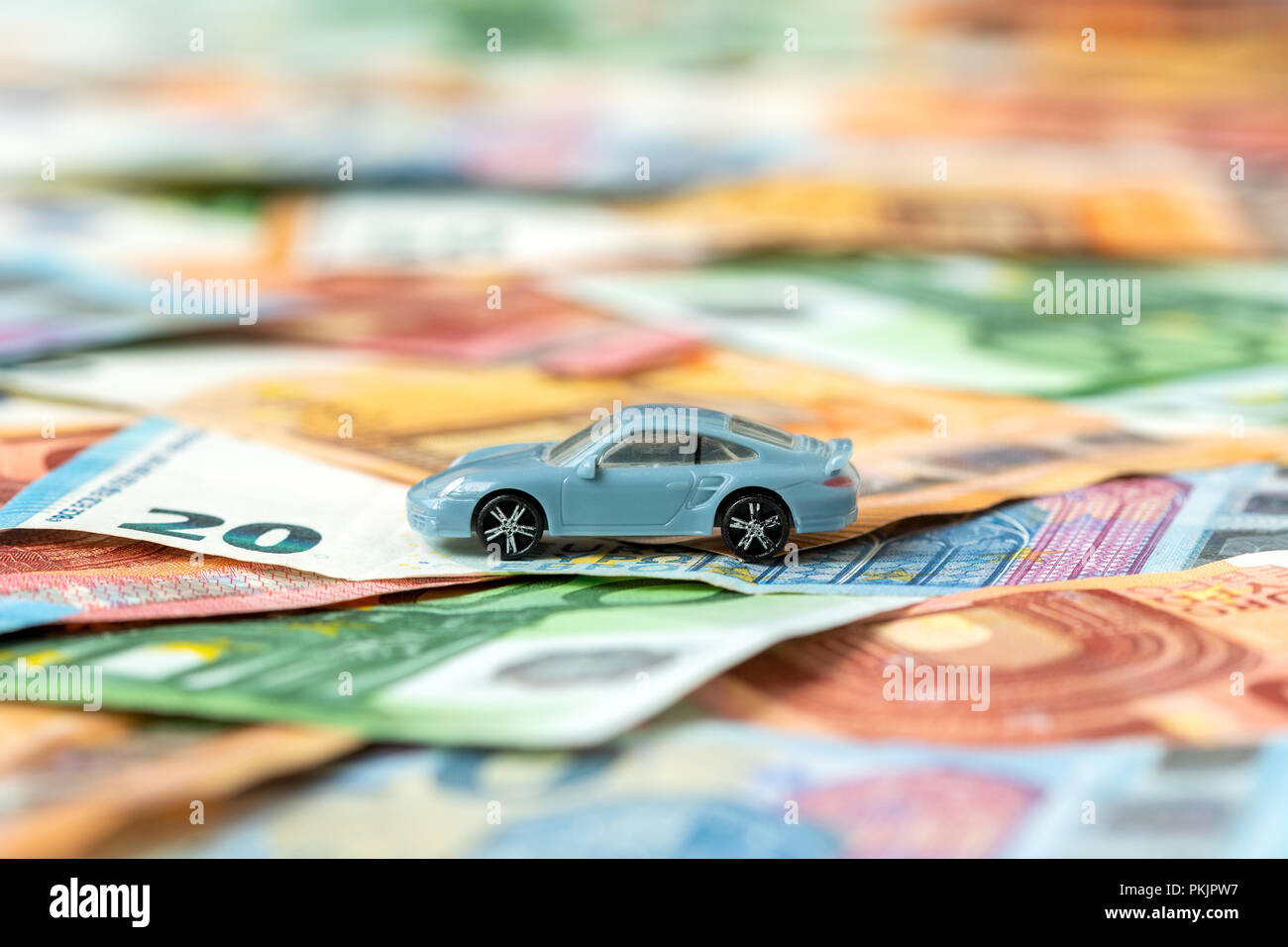 Car model on money background. Saving money for a car Stock Photo - Alamy