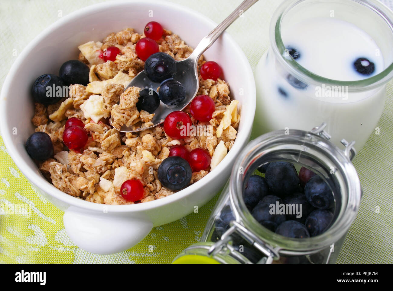 Healthy breakfast muesli with blueberry and red currant and milk with ...