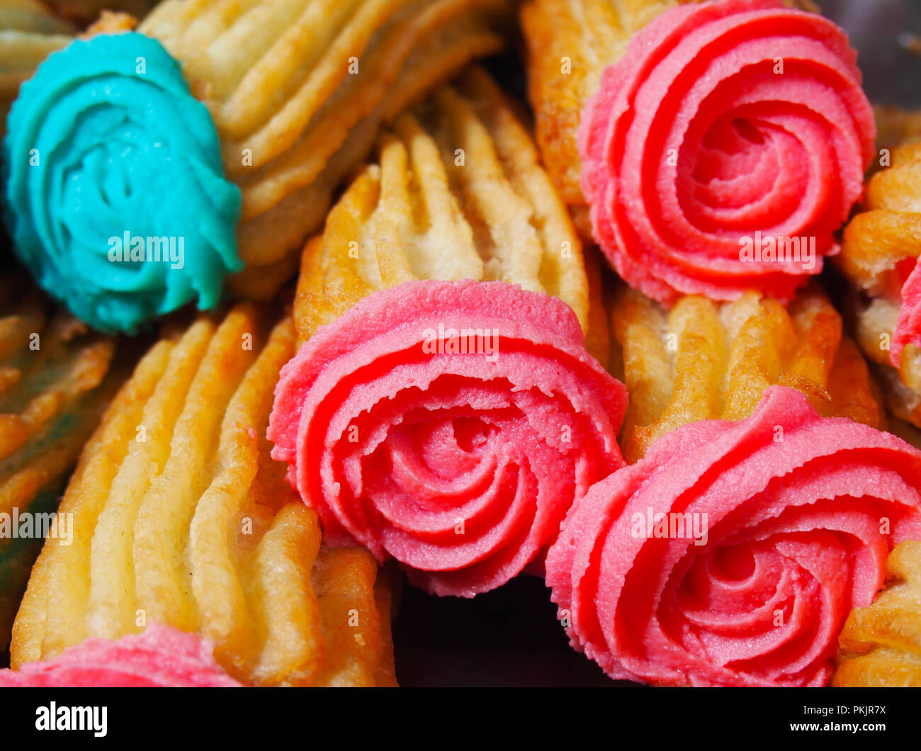 Spanish traditional fried-dough pastry churros in in colored glaze ...