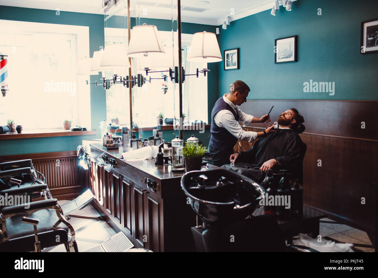 Barbershop with wooden interior. Bearded model man and barber Stock ...
