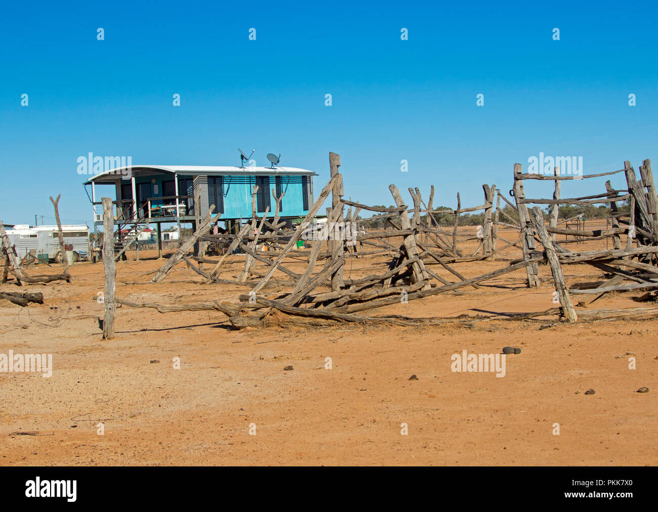 Modern house on high stumps with verandah and bright blue walls beside ...