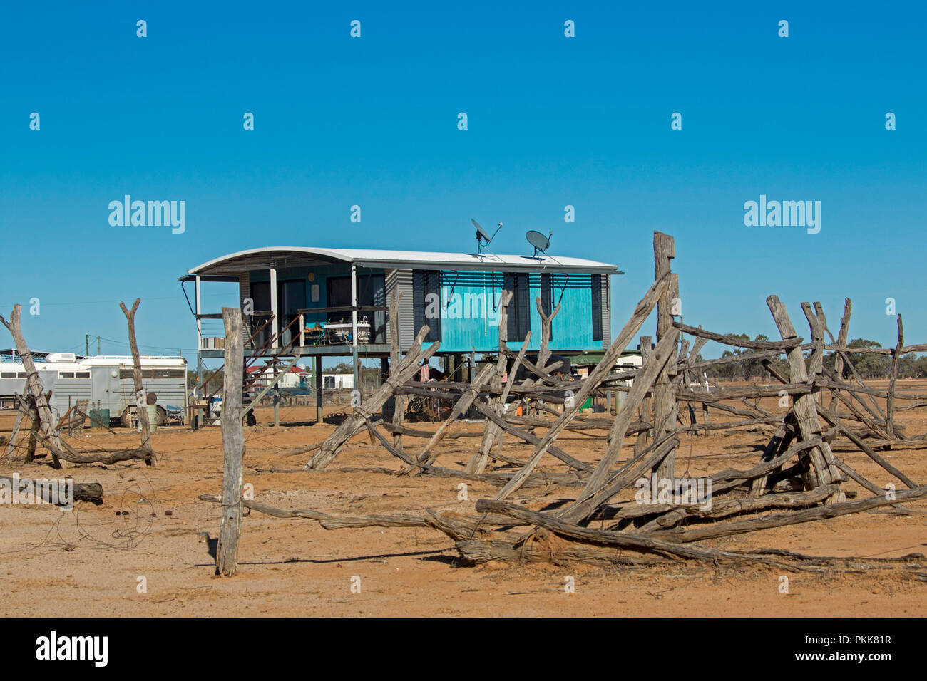 Modern house on high stumps with verandah and bright blue walls beside ...