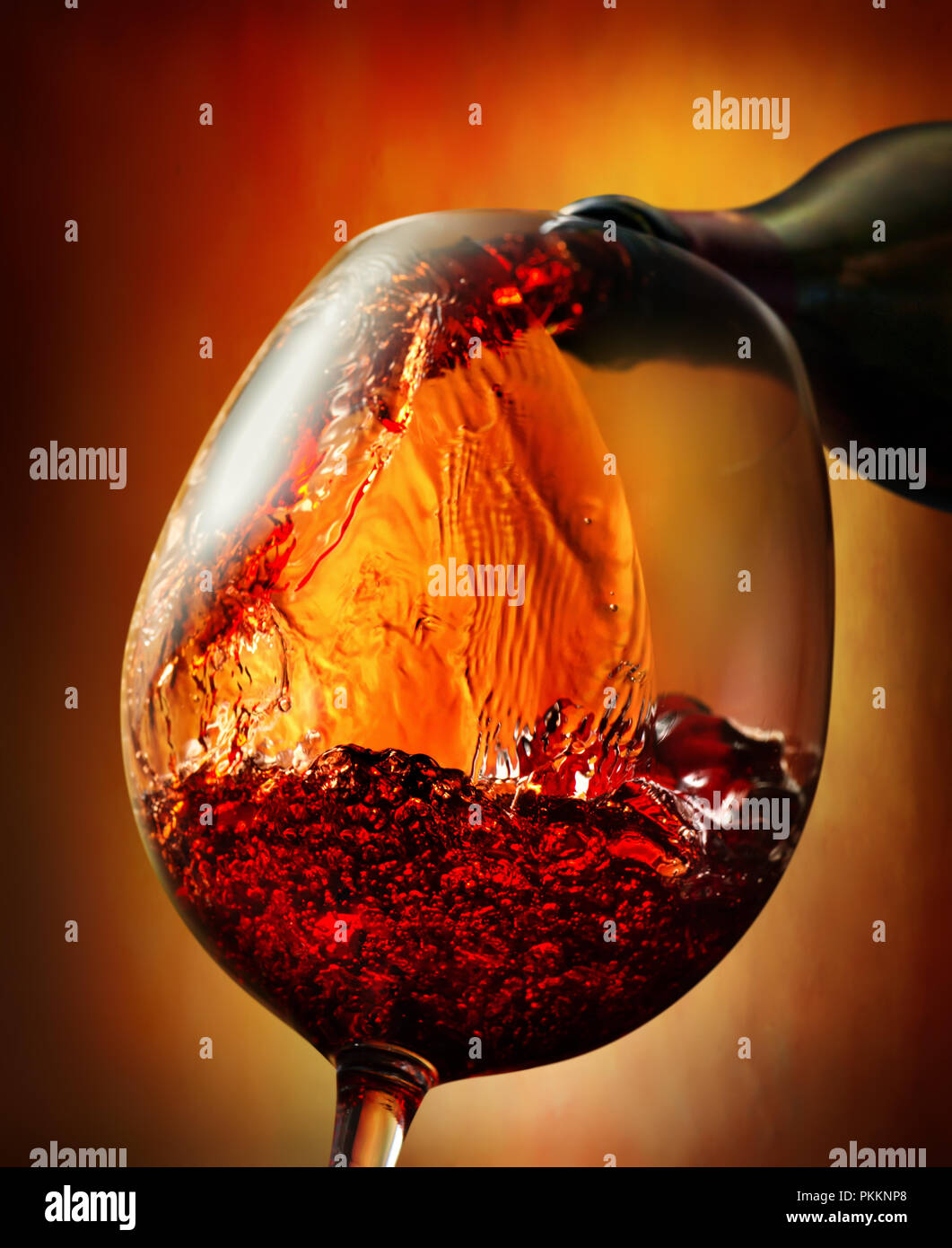 Red wine pouring into wineglass on an orange background Stock Photo - Alamy