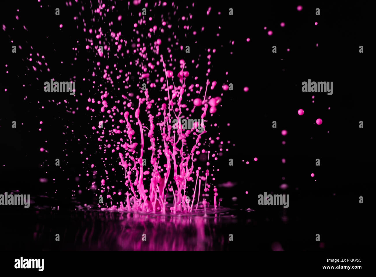 Magenta, pink paint, ink splash on black background Stock Photo - Alamy
