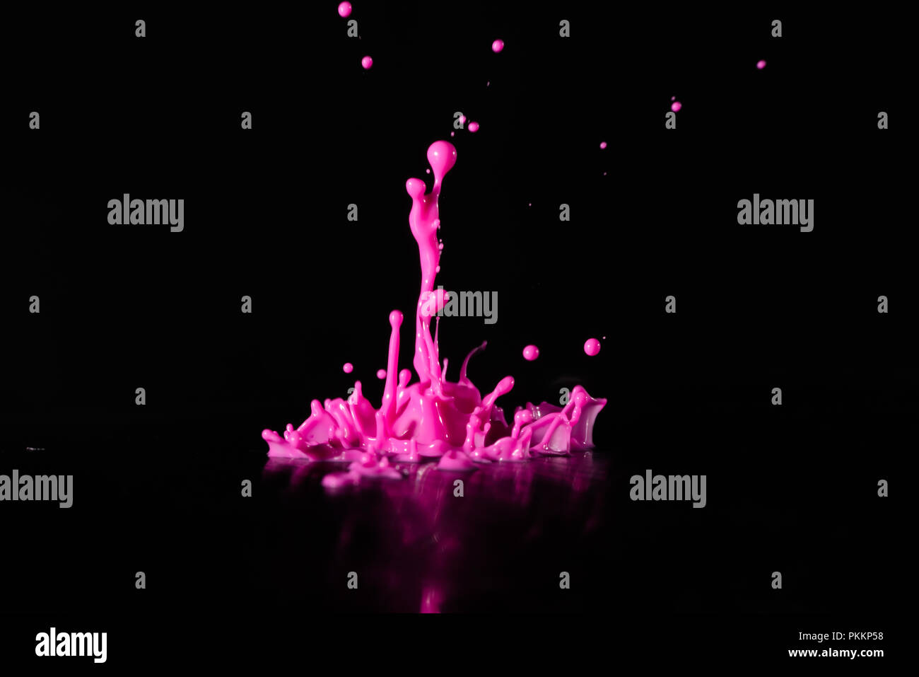 Magenta, pink paint, ink splash on black background Stock Photo - Alamy