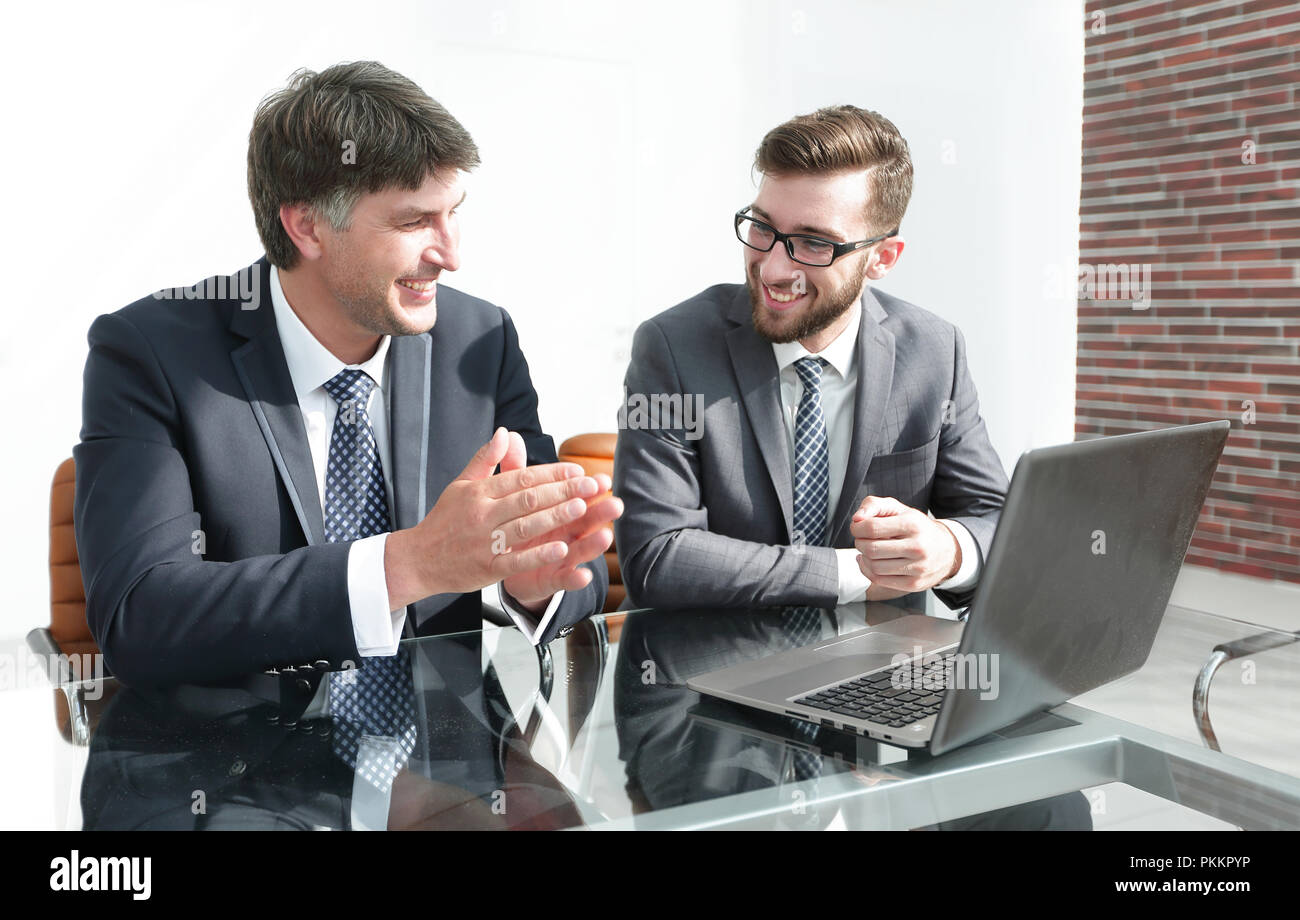 Portrait of two business people sitting at office desk Stock Photo - Alamy