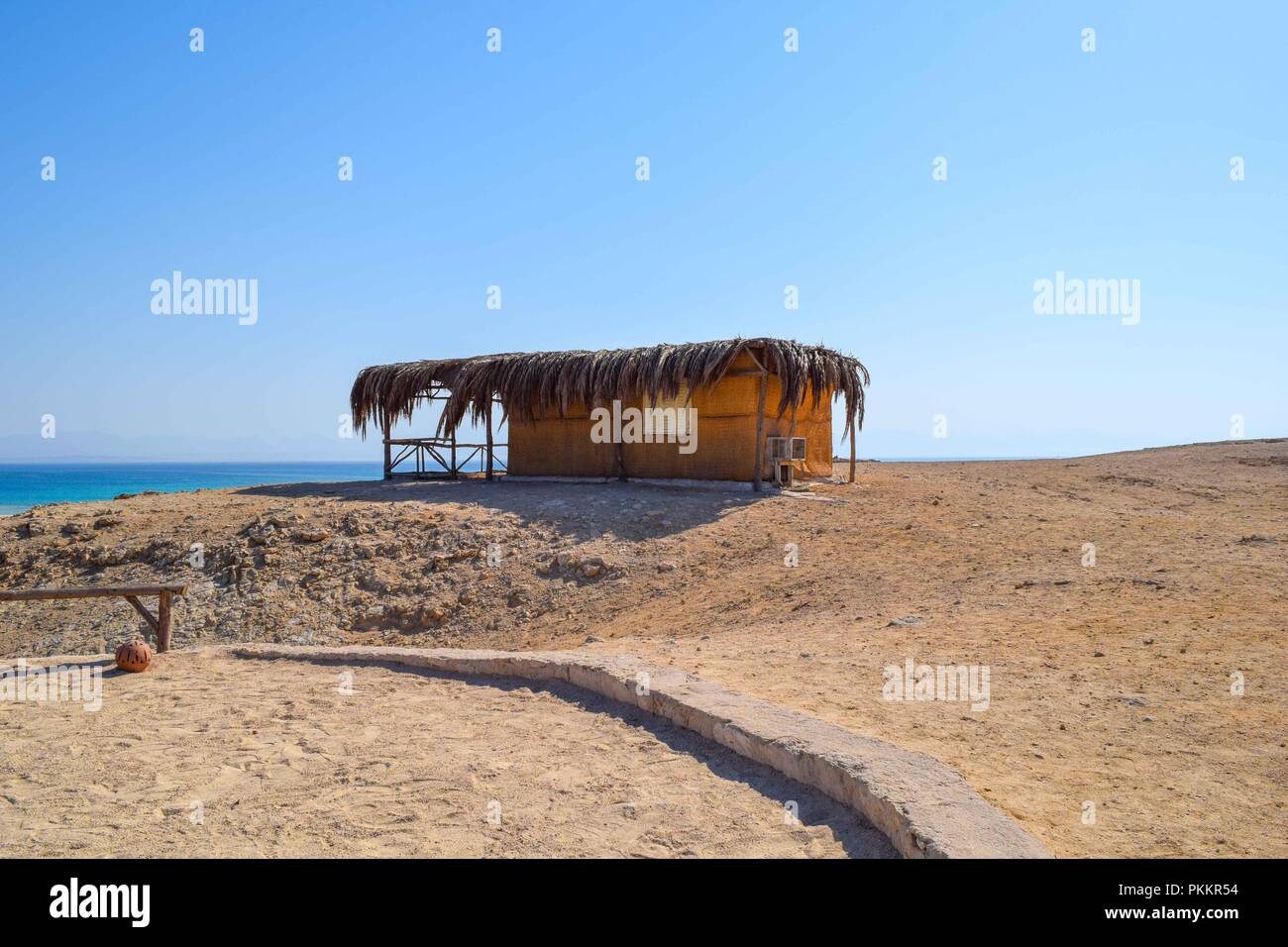 Hut in sand in front of the ocean on a hill, in front of blue sky Stock ...