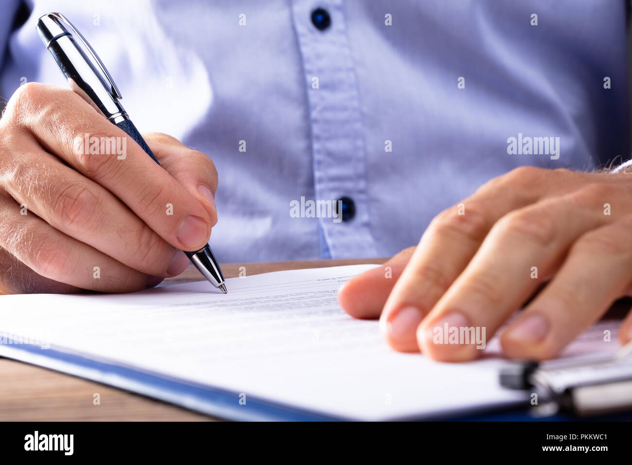 Men at a table signing papers hi-res stock photography and images - Alamy