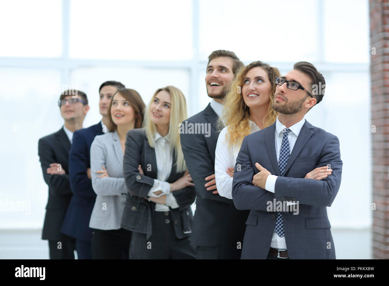 smiling business team looking up Stock Photo - Alamy