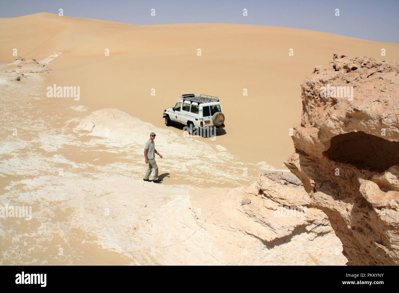 Tourist walking back to the off-road vehicle during an Sahara desert ...