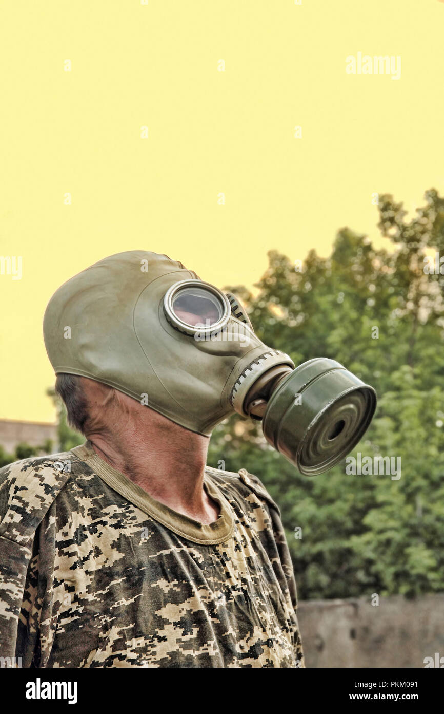 Men in gas mask at poisoned environment looks on the chemical sky ...
