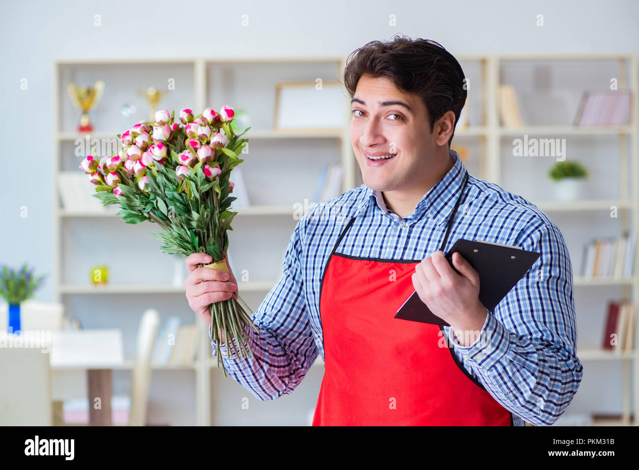 Flower shop assistant offering a bunch of flowers Stock Photo - Alamy