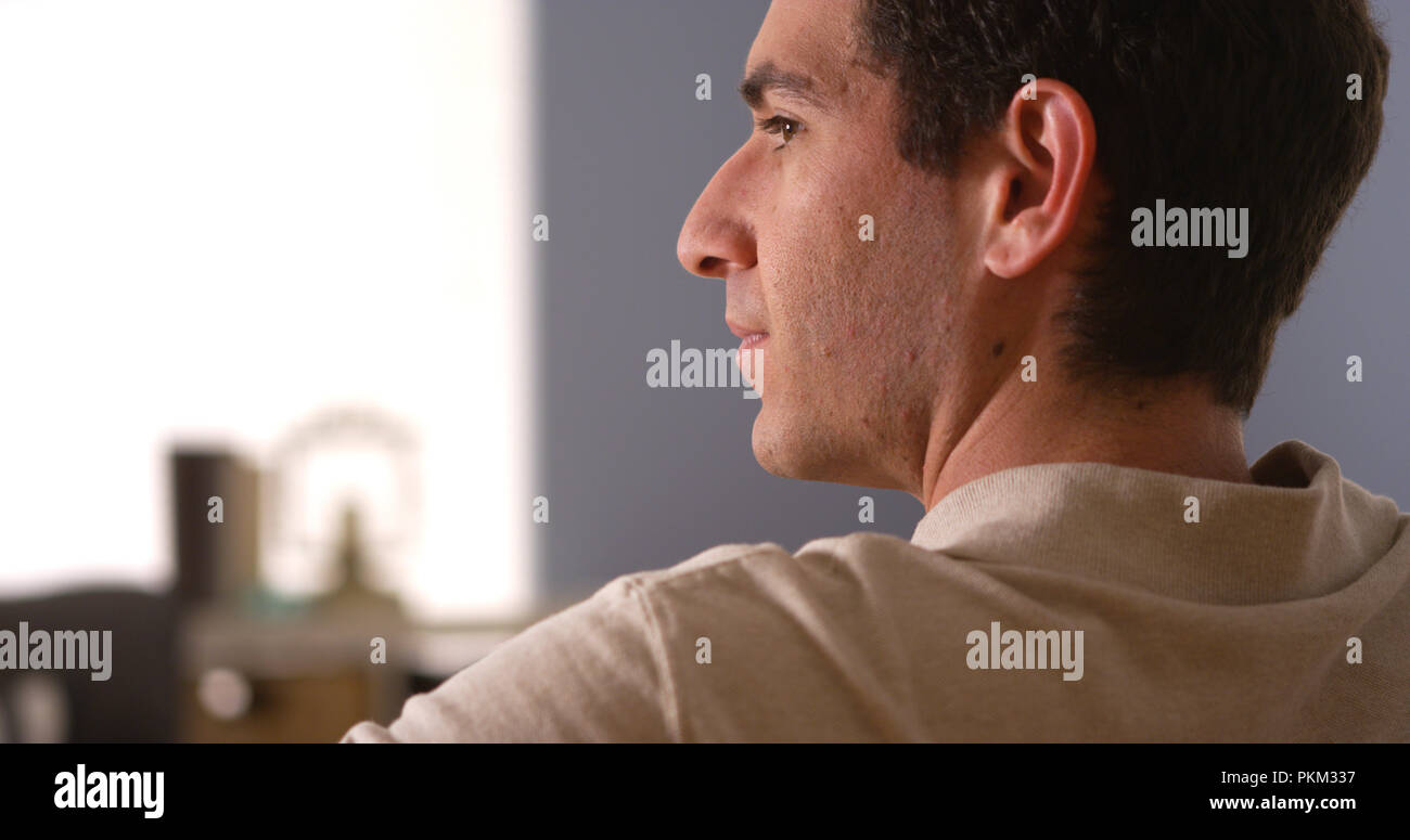 Man thinking while sitting in living room Stock Photo - Alamy