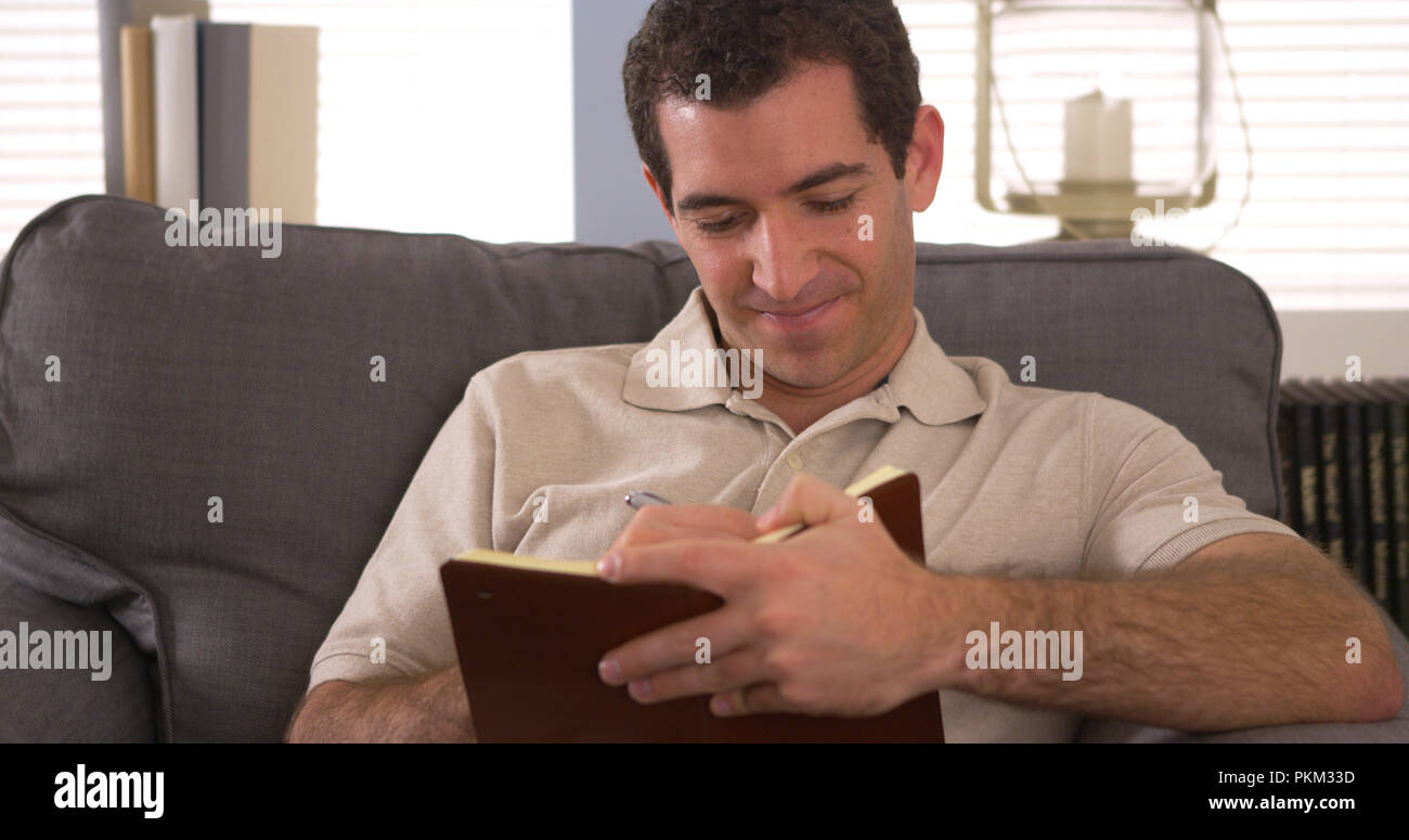 Man writing down notes in book Stock Photo - Alamy