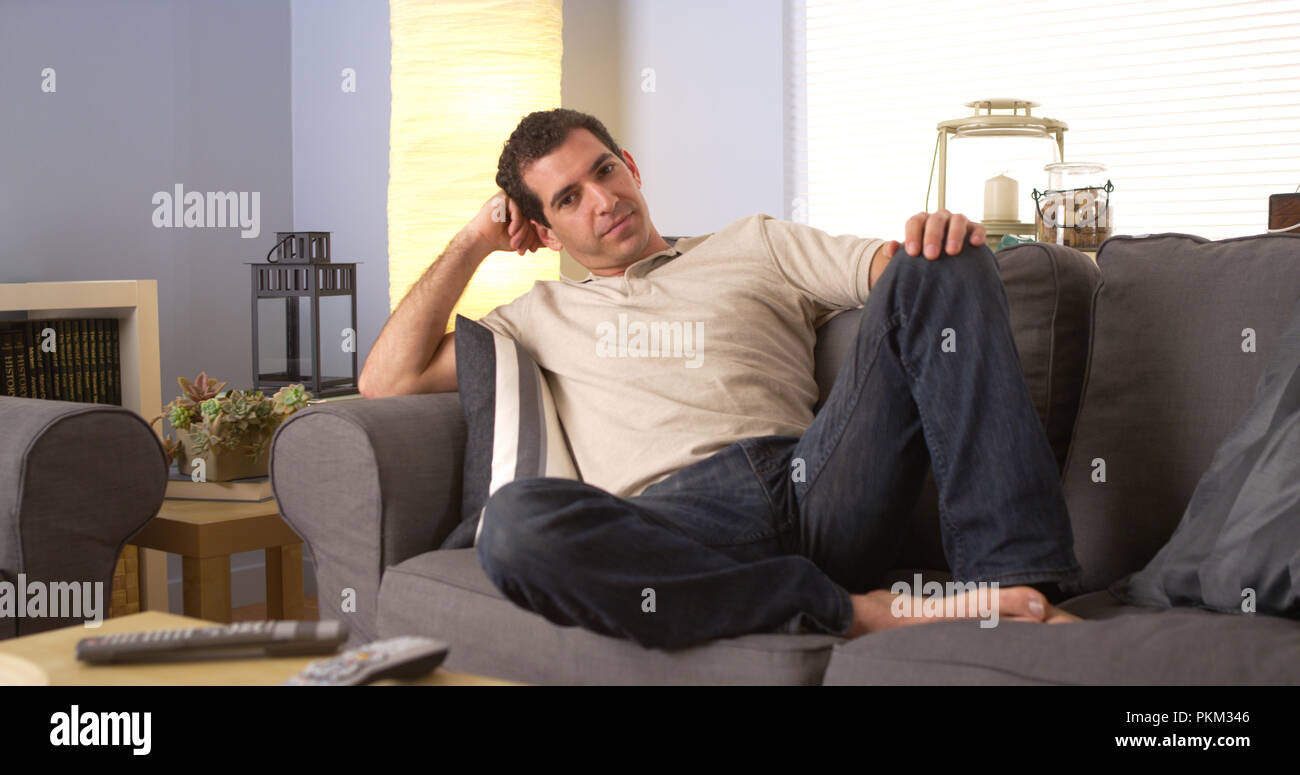Tired man resting on couch at home Stock Photo - Alamy