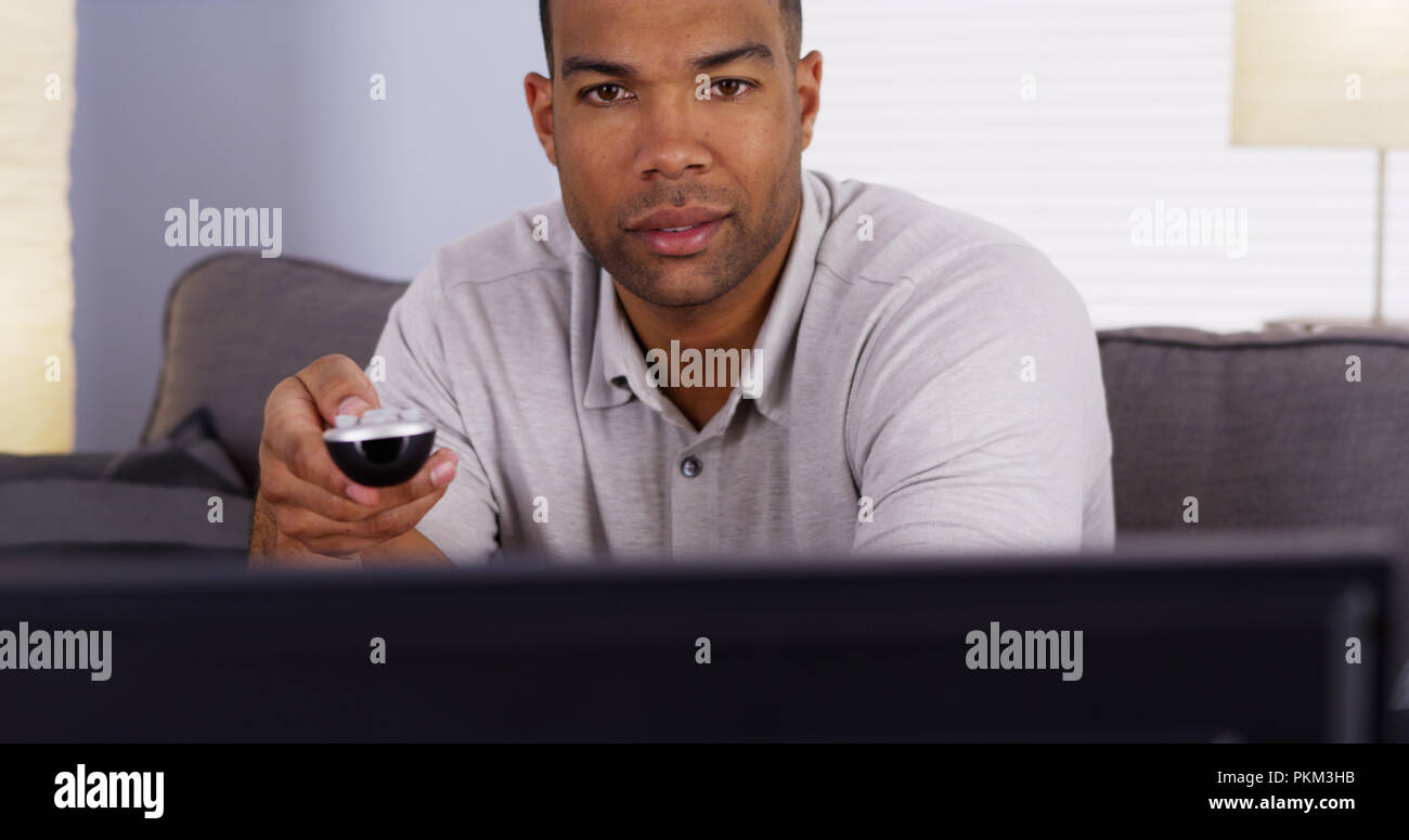African man flipping through channels on TV Stock Photo - Alamy
