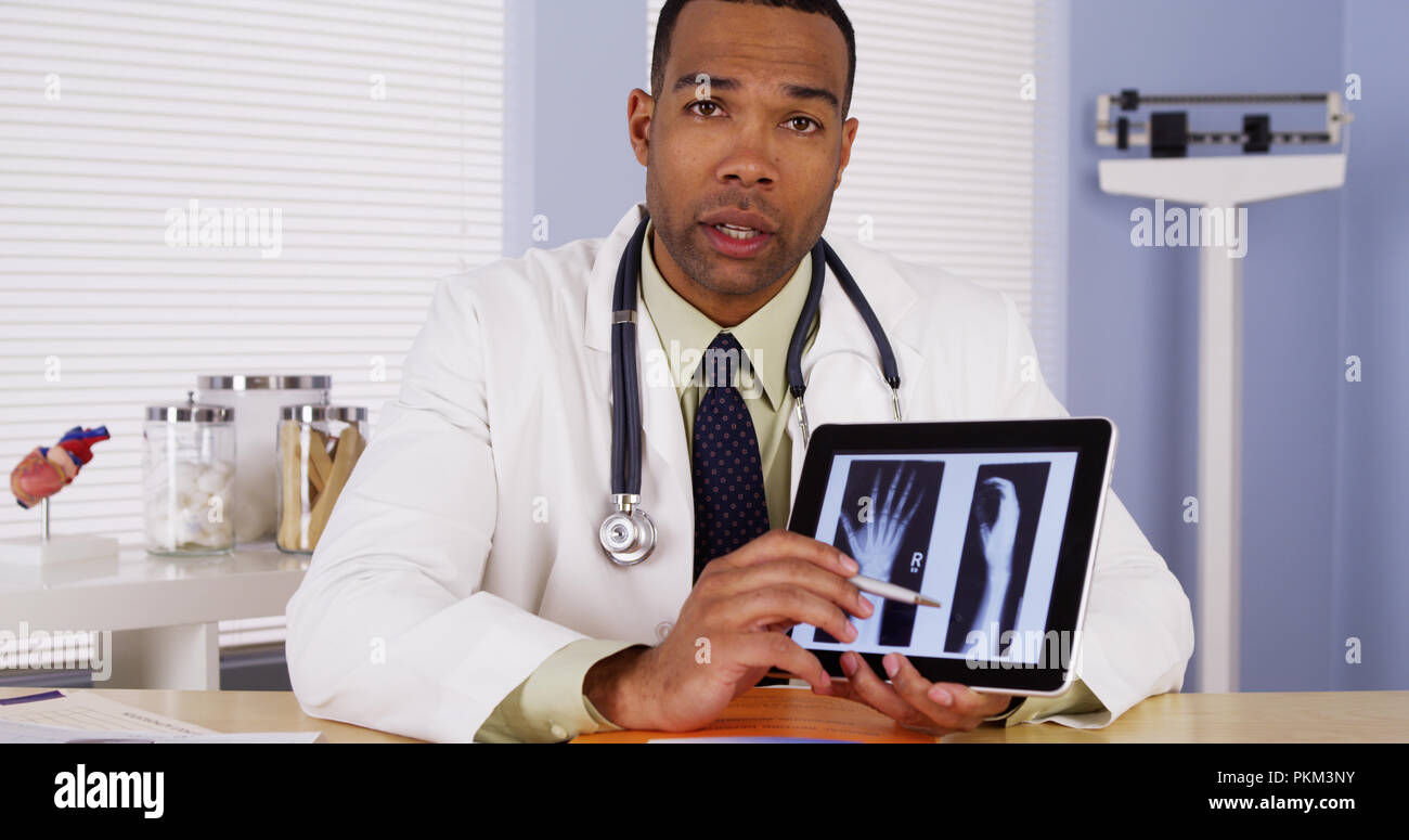 Black doctor listening and talking to camera Stock Photo - Alamy