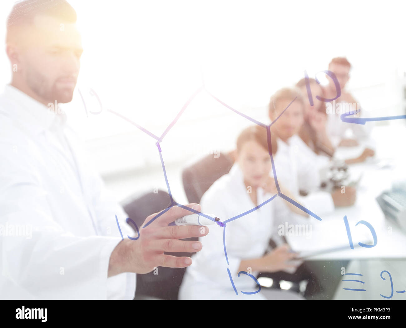 from behind the glass. a scientist standing near the blackboard in the ...