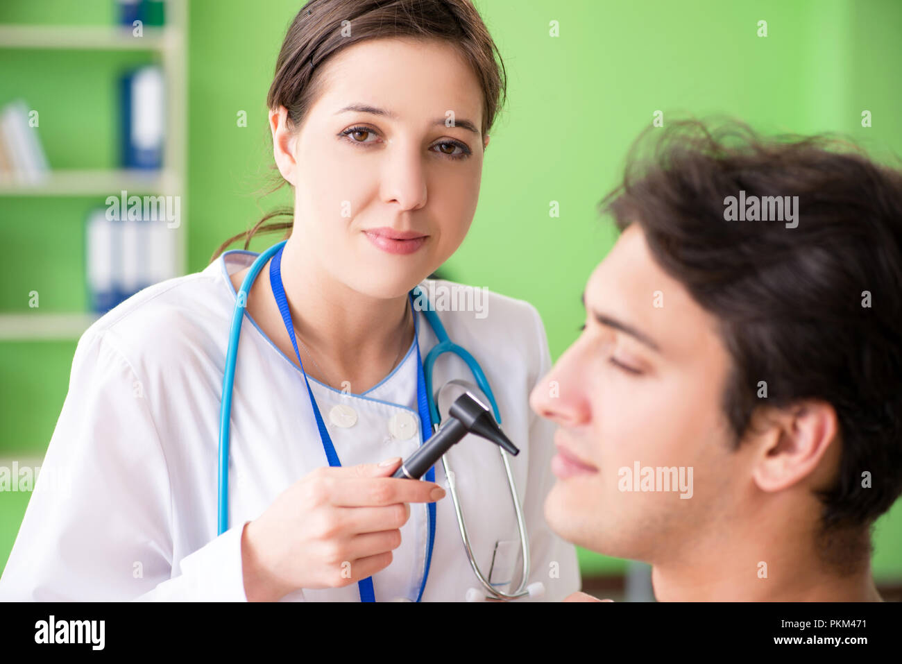 Female doctor checking patient's ear during medical examination Stock ...