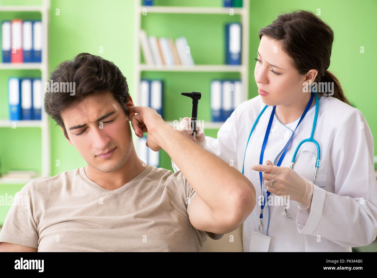 Female doctor checking patient's ear during medical examination Stock ...