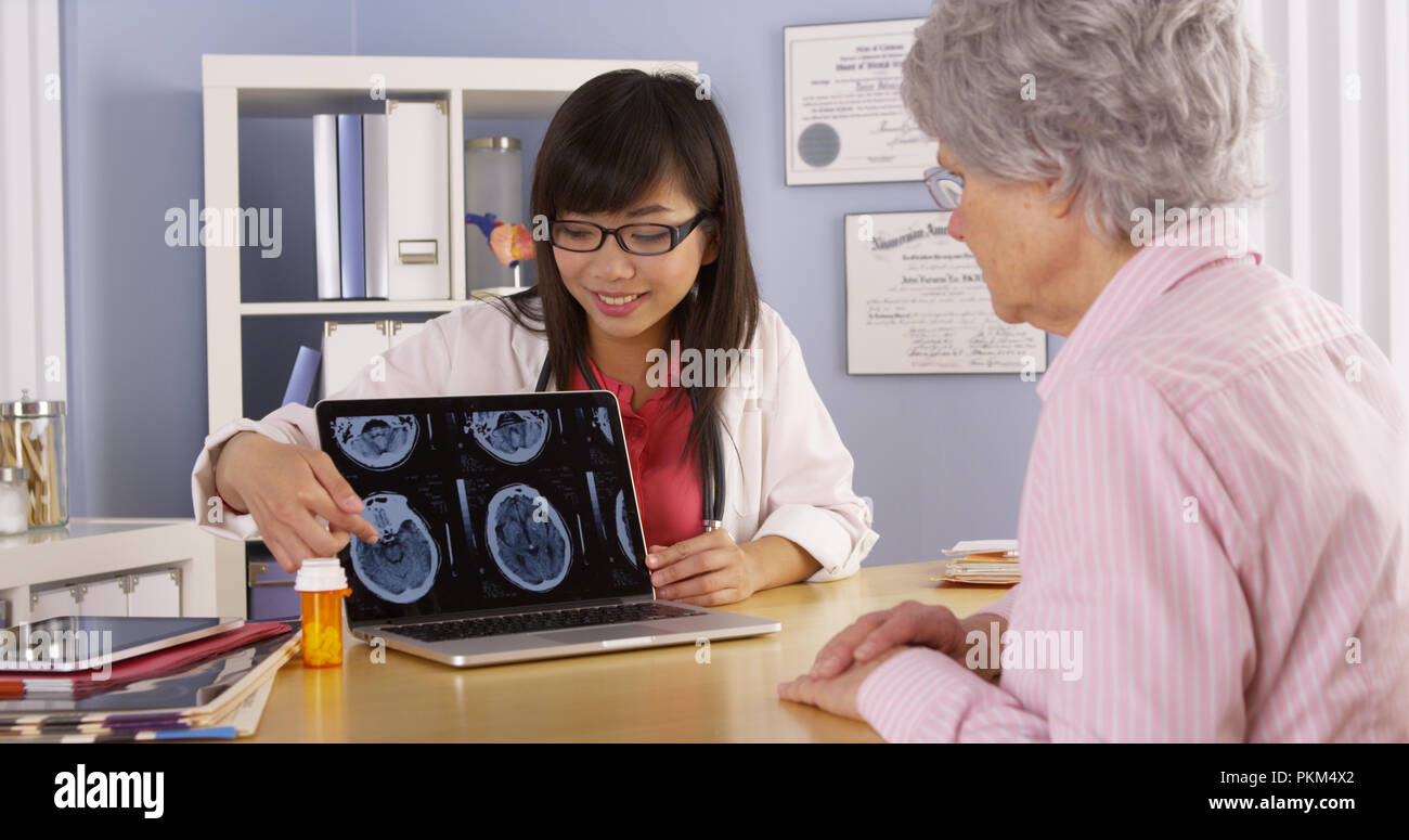 Asian doctor explaining brain scans to elderly patient Stock Photo - Alamy