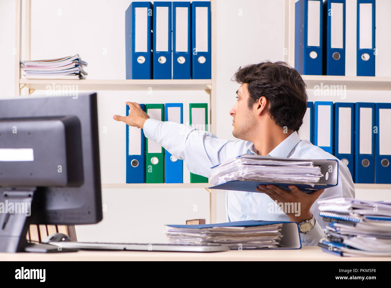 Overloaded busy employee with too much work and paperwork Stock Photo ...