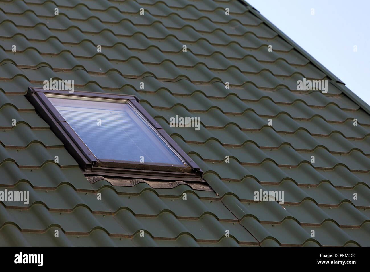 Close-up detail of new small attic plastic window installed in dark ...