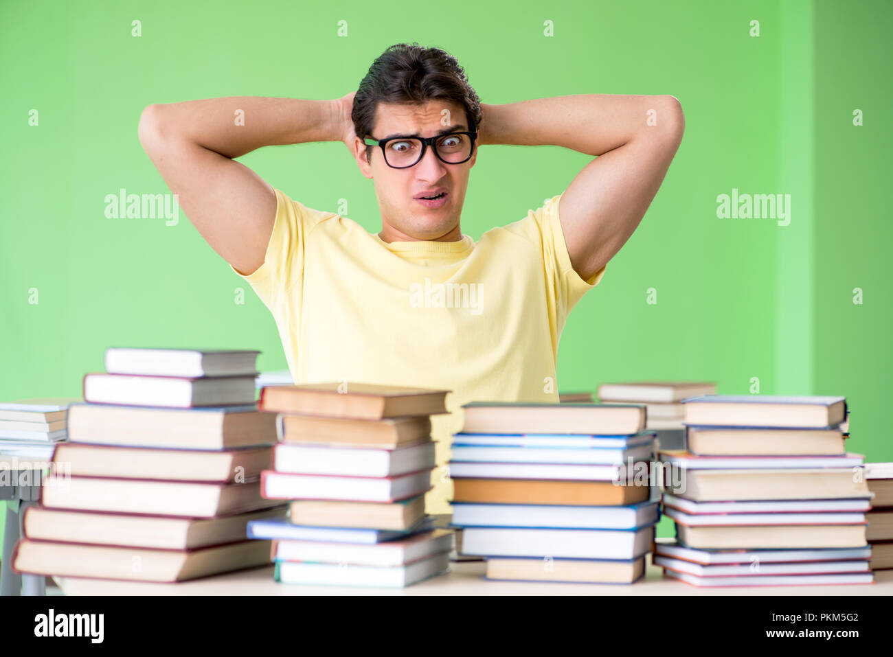 Student with too many books to read before exam Stock Photo - Alamy