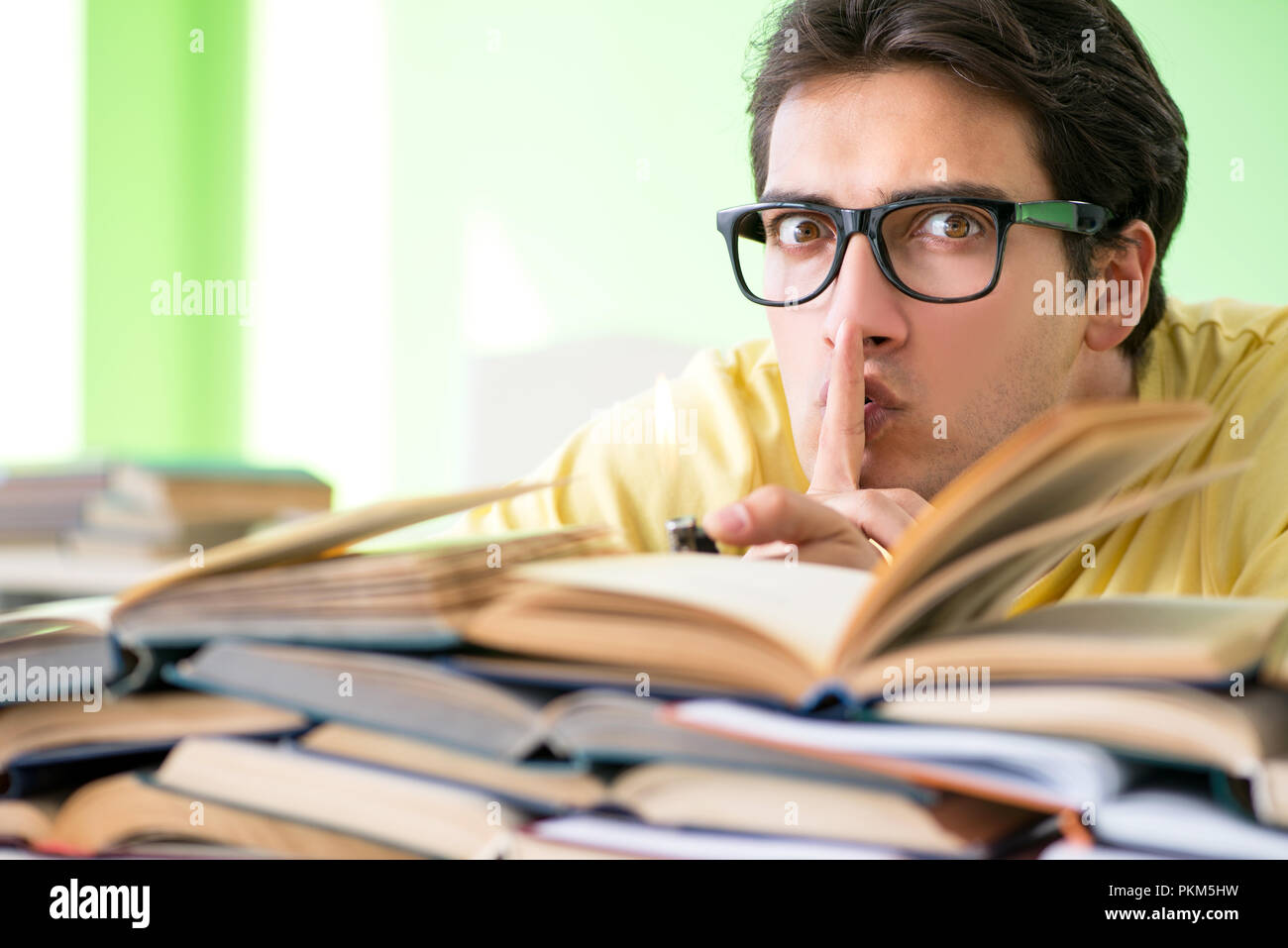 Student with too many books to read before exam Stock Photo - Alamy